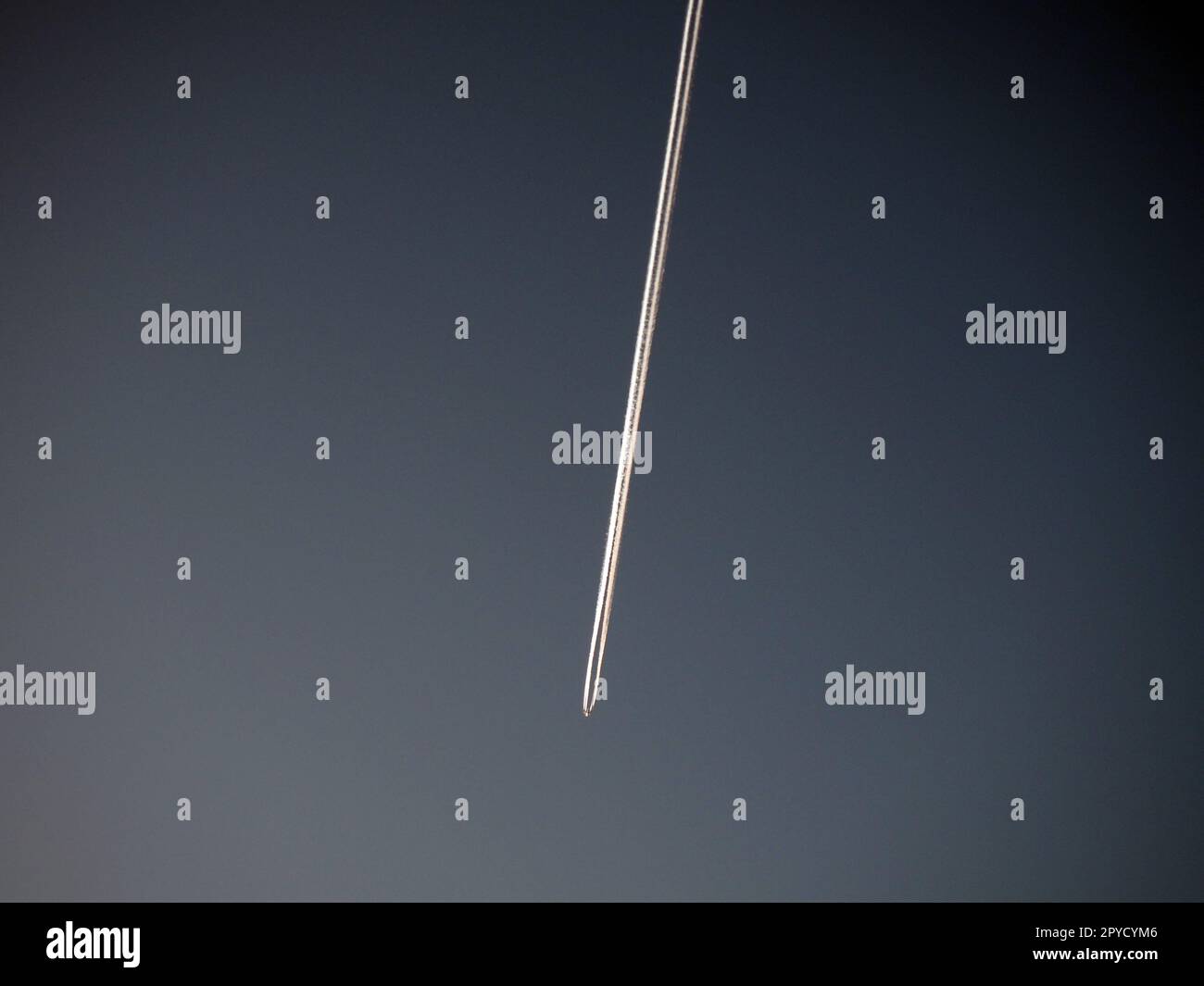 The trail from an airplane flying in the sky. Evening sky. Emissions of ...