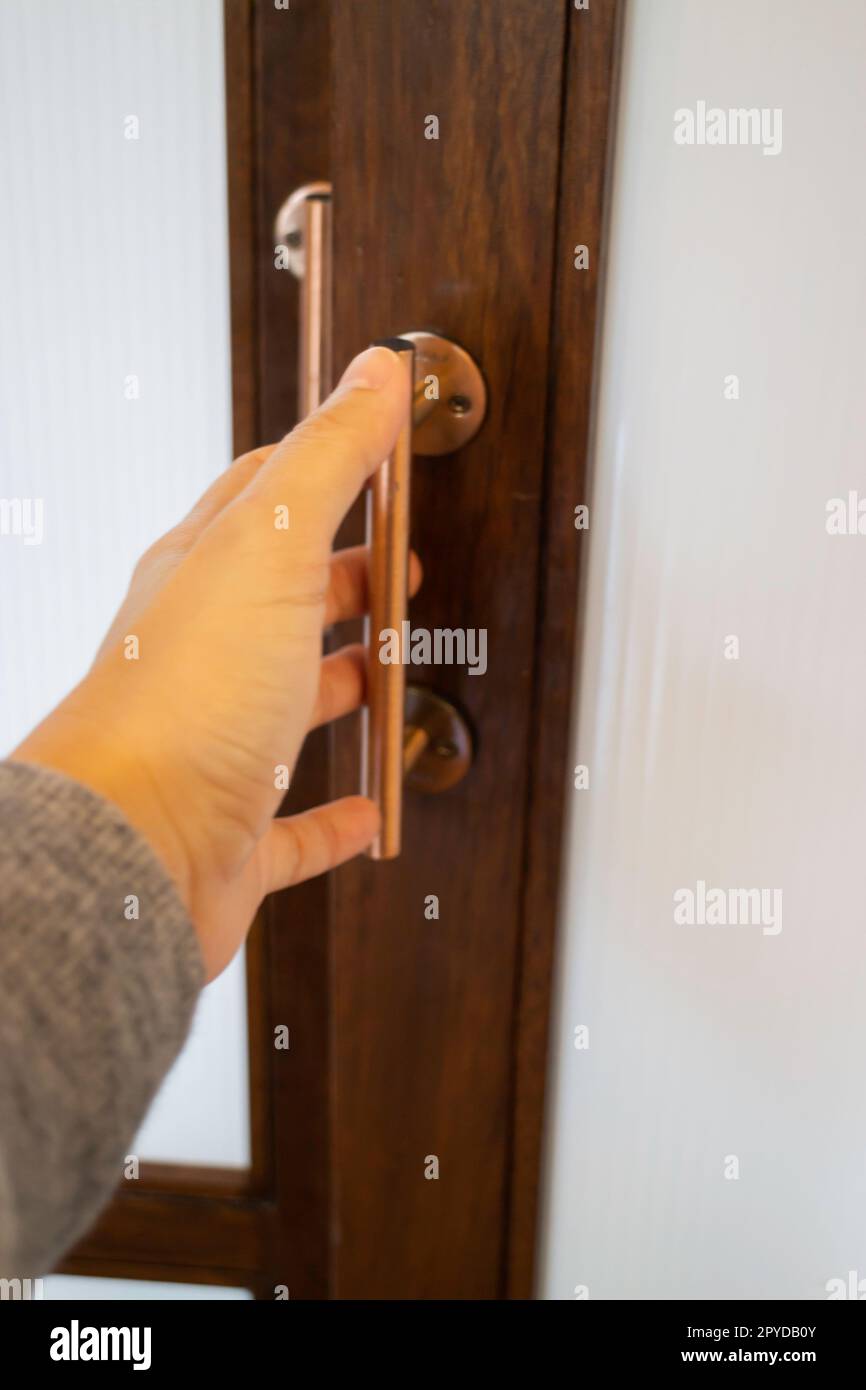 Hand on metal door holder Stock Photo - Alamy