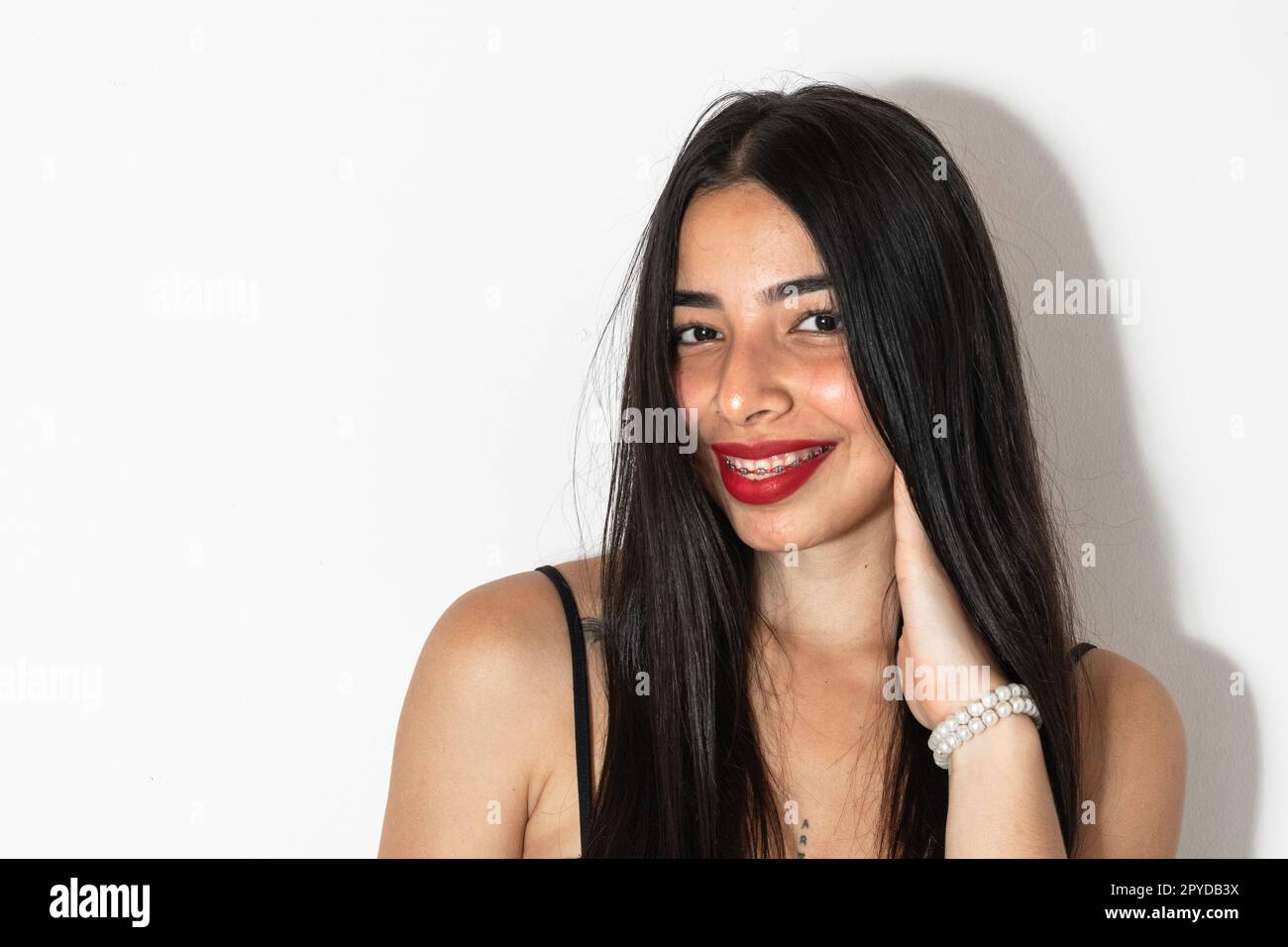 close-up portrait of a beautiful young latina woman with a hand on her cheek smiling Stock Photo ...