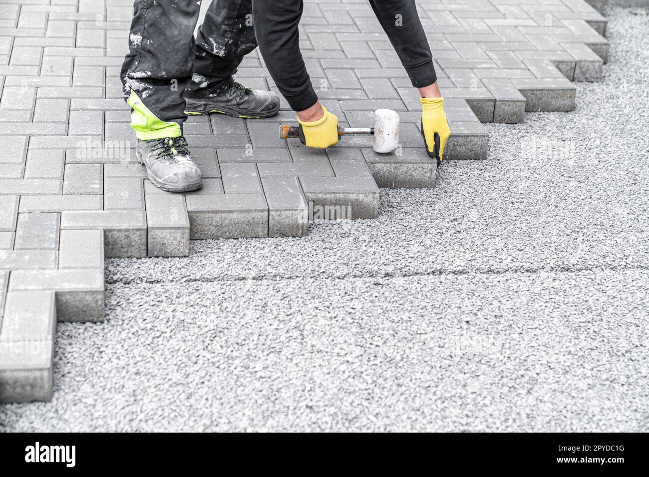 laying interlocking pavers during the construction of sidewalks and ...