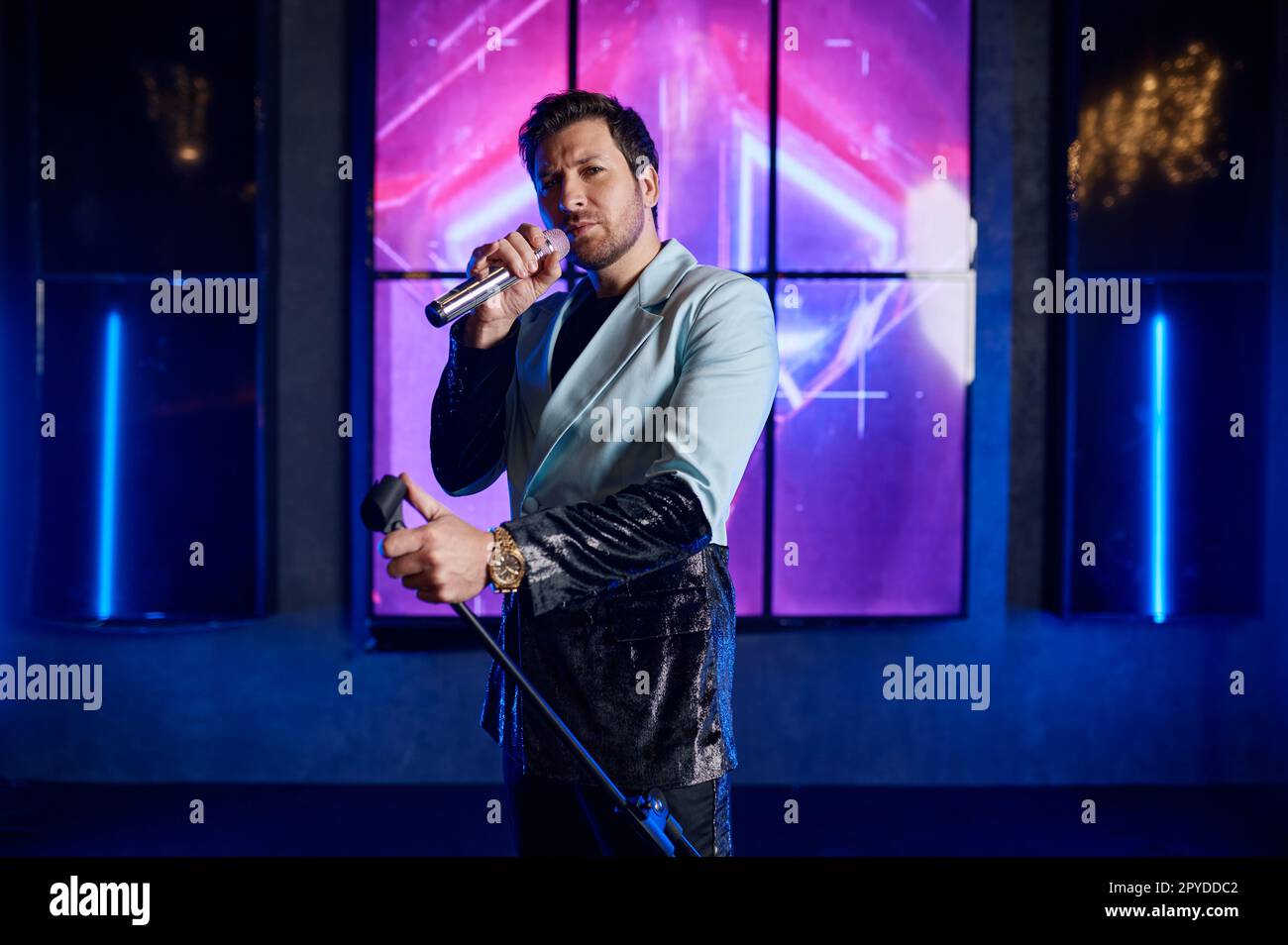 Male singer holding microphone standing and performing on stage Stock ...