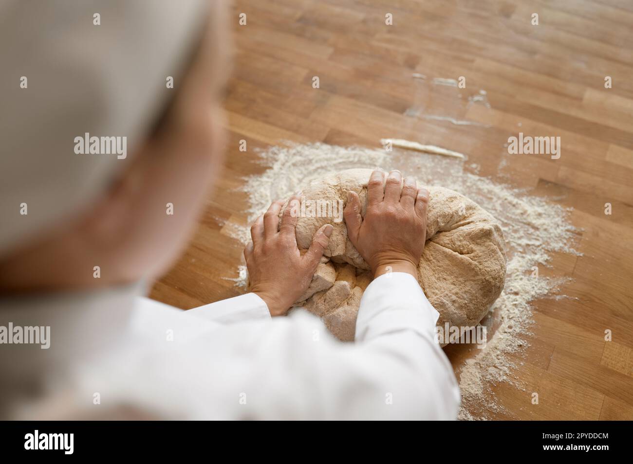 Baking process, closeup baker hands kneading dough on table Stock Photo - Alamy