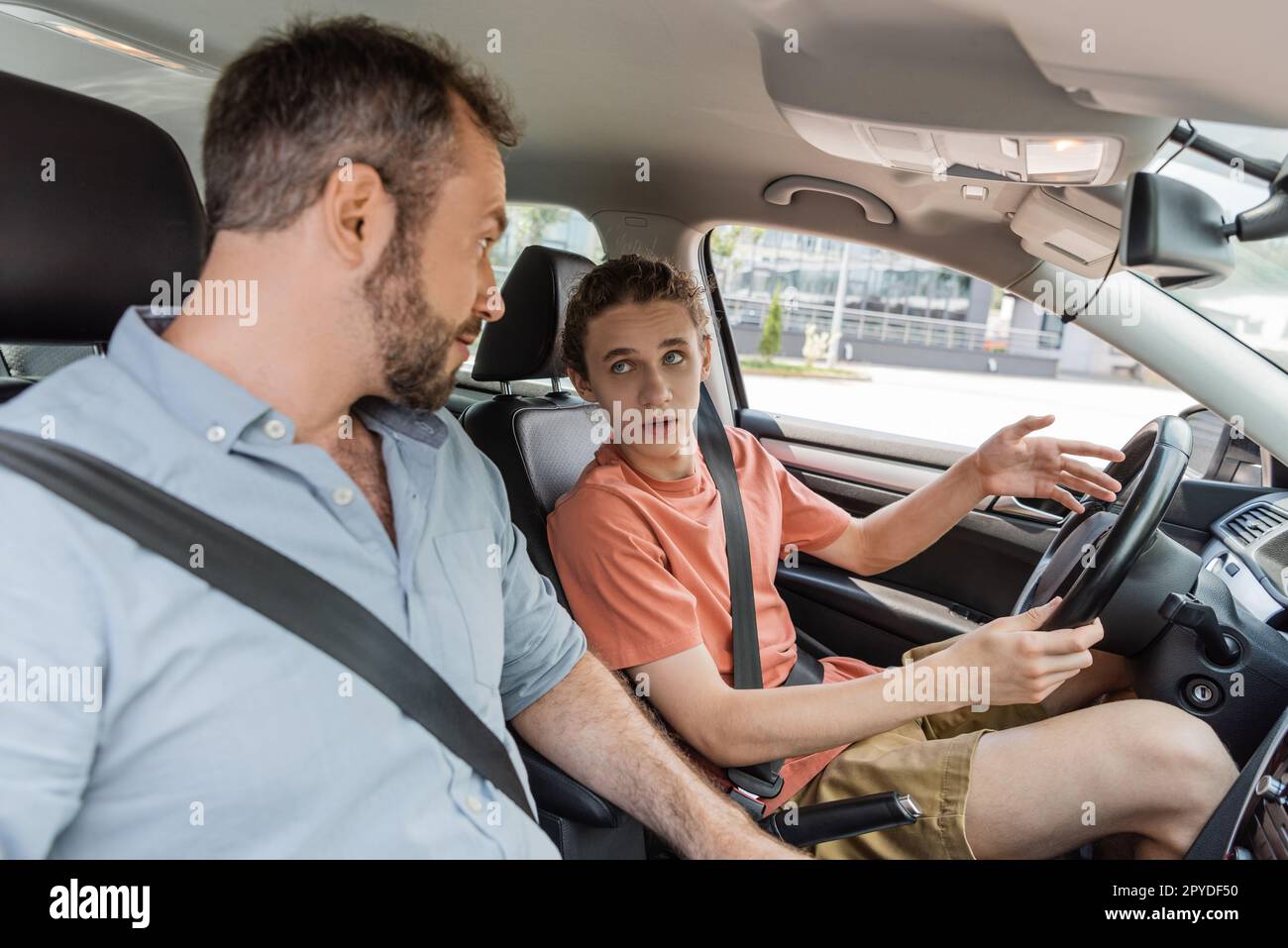 teenaged boy sitting next to dad while learning how to drive car,stock ...