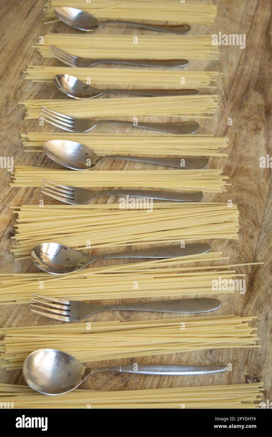 spaghetti and silver cutlery alternated Stock Photo - Alamy