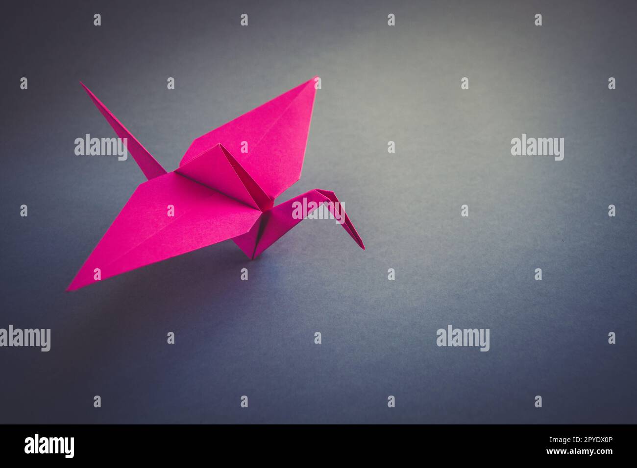 Pink paper crane origami isolated on a grey background Stock Photo - Alamy