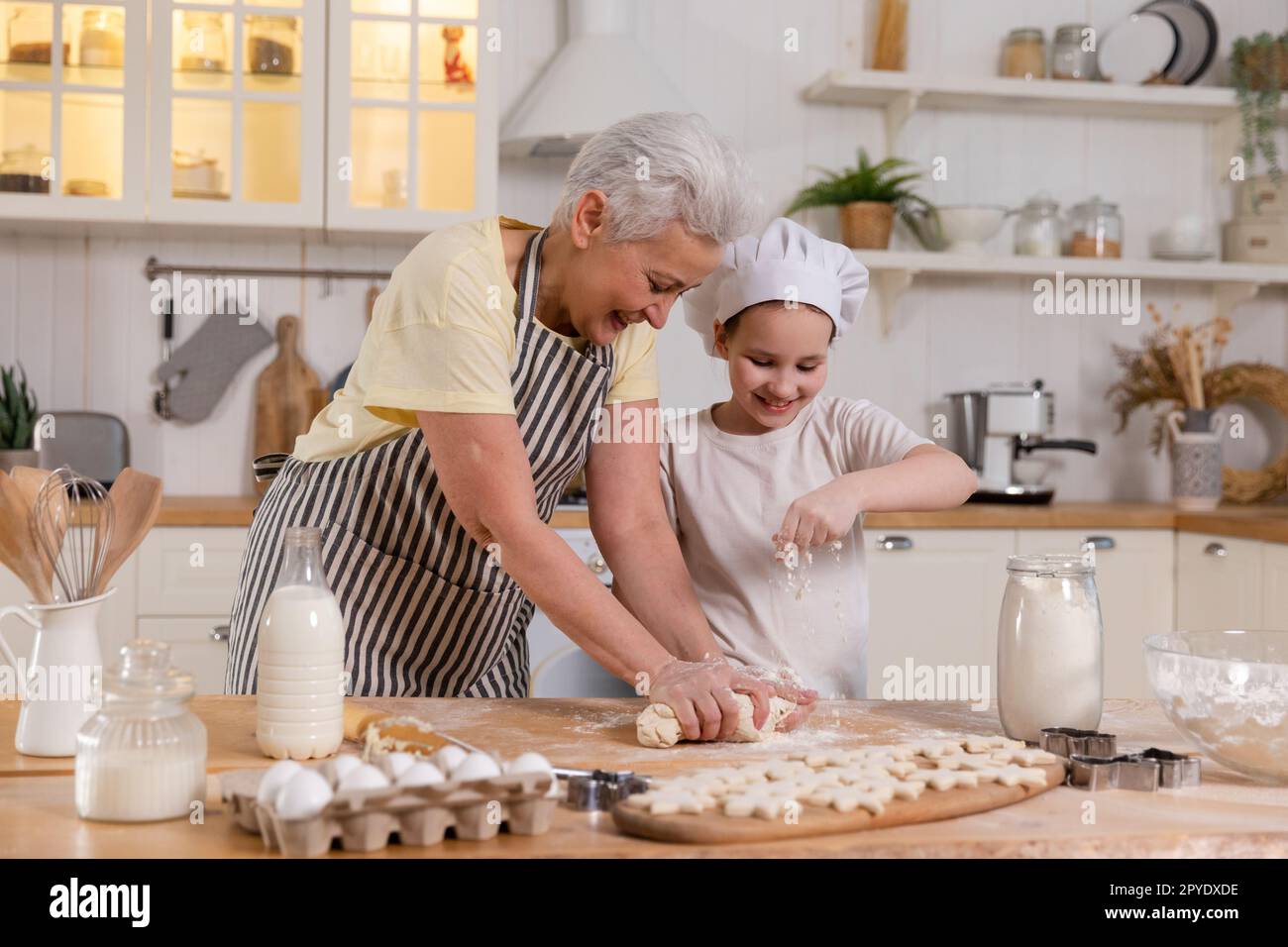 Happy family in kitchen. Grandmother and granddaughter child cook in ...