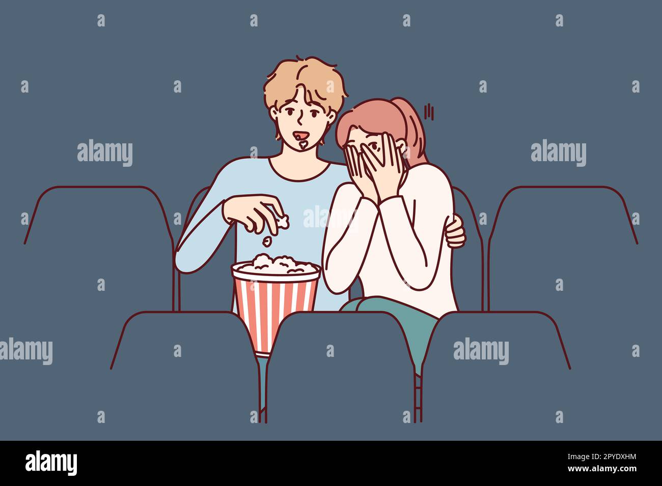 Guy and girl are watching horror movie in cinema and eating popcorn ...