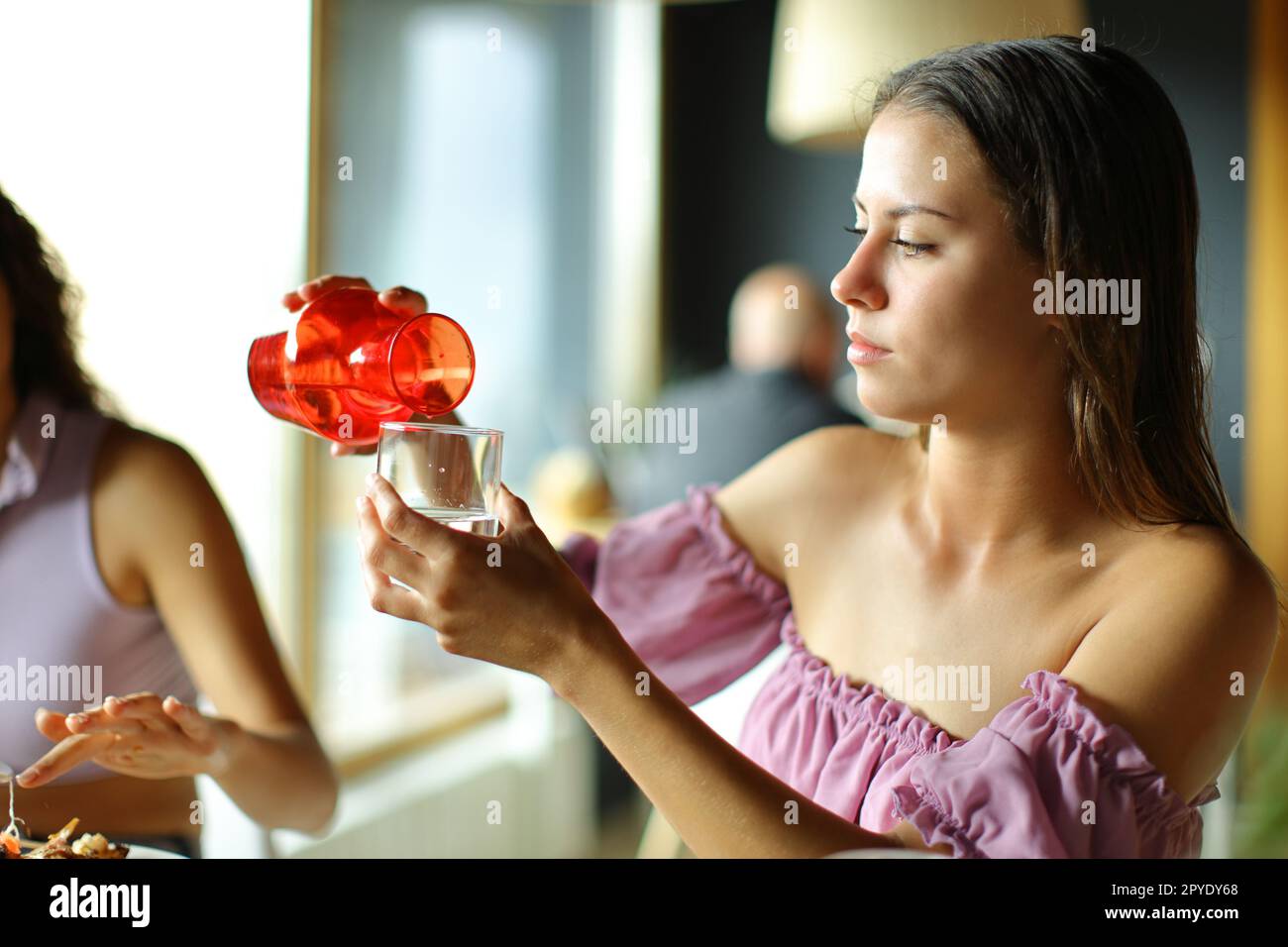 Woman filling glass with water in a restaurant Stock Photo - Alamy