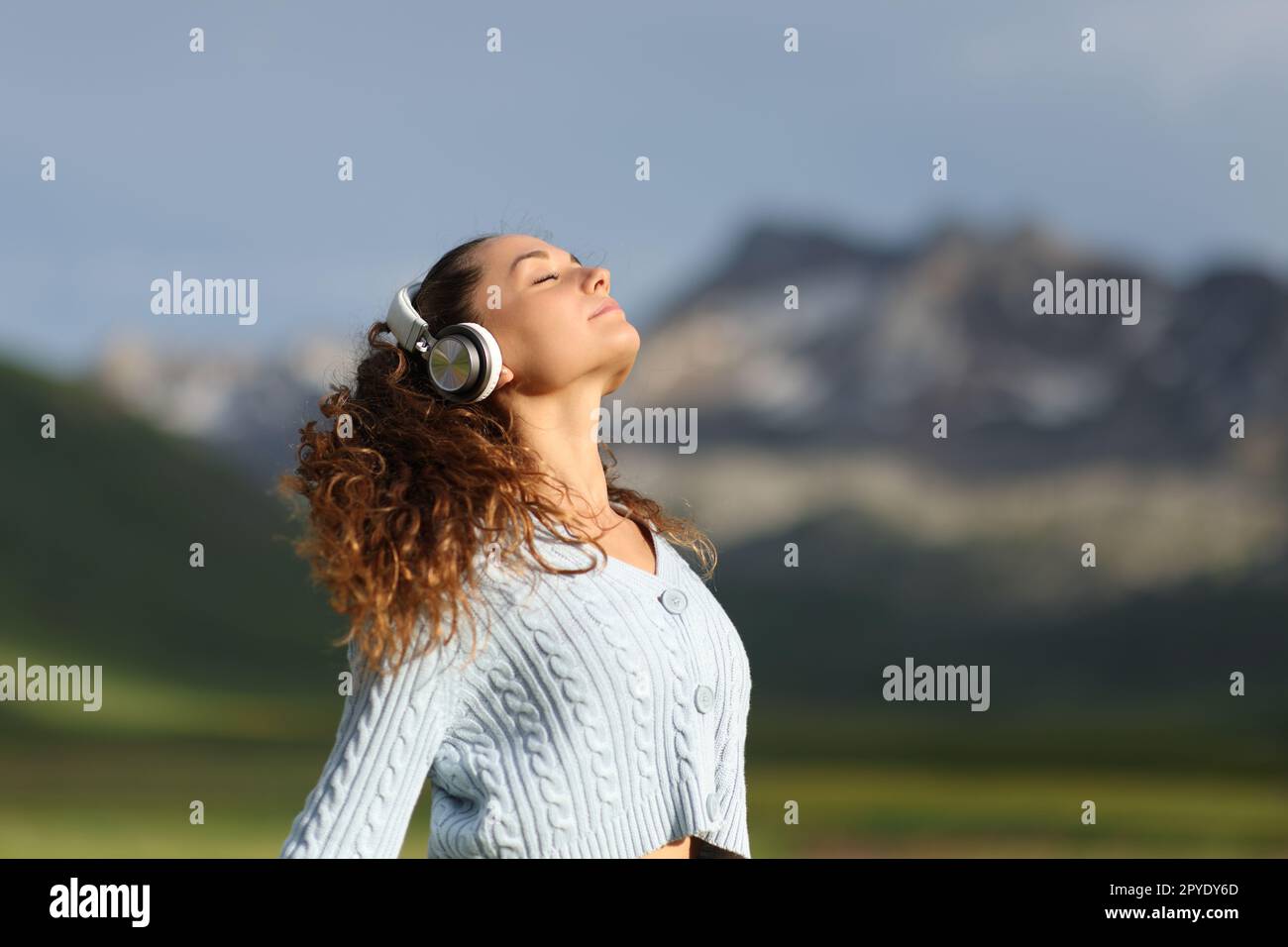Woman meditating in nature listening audio guide Stock Photo - Alamy