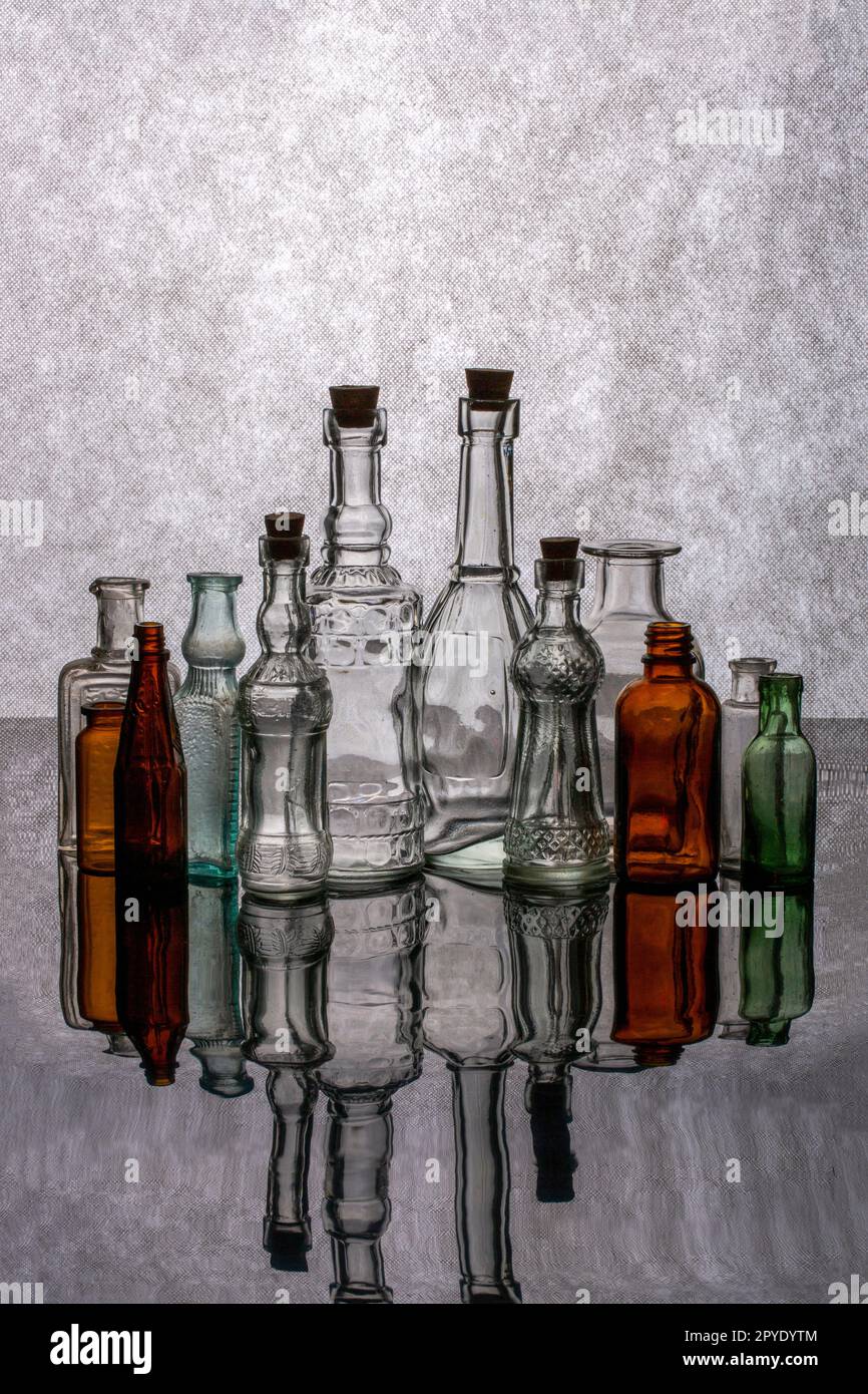 Still life with old glass bottles with reflection Stock Photo - Alamy