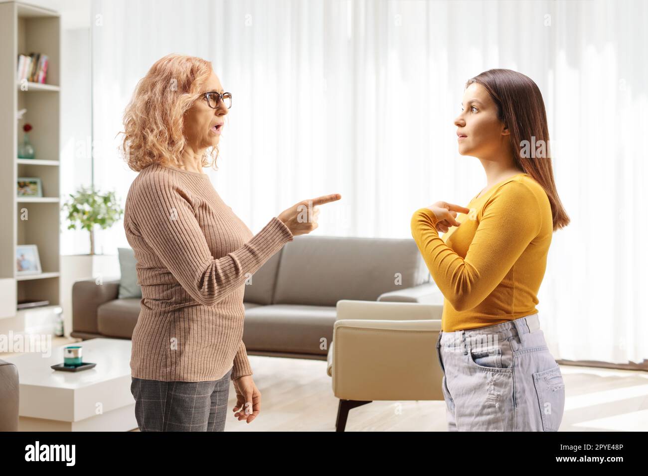Profile shot of a mother arguing with teenage daughter at home in a ...