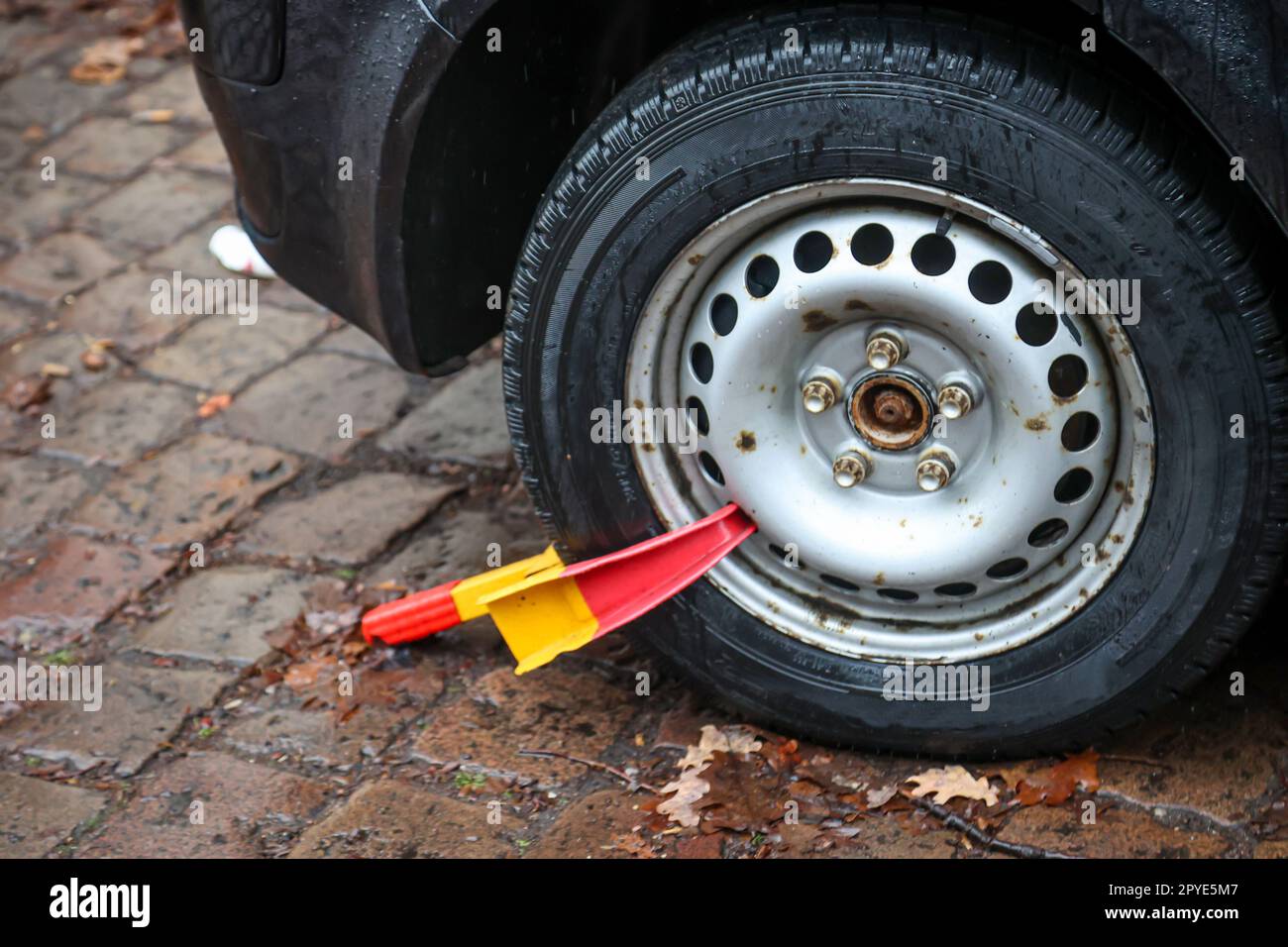 A car is prevented from moving forward by a parking claw, tire claw ...