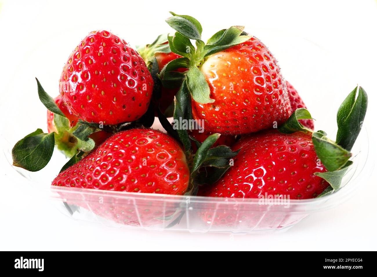 Ripe strawberries in a plastic package on a white background. Delicious ...