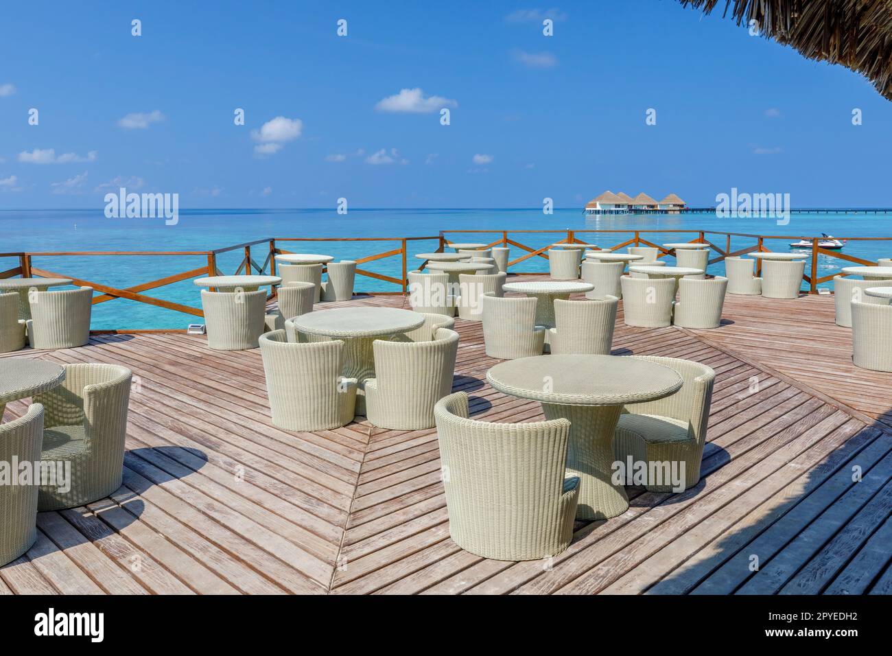 Tables on the open veranda in the restaurant overlooking the ocean ...