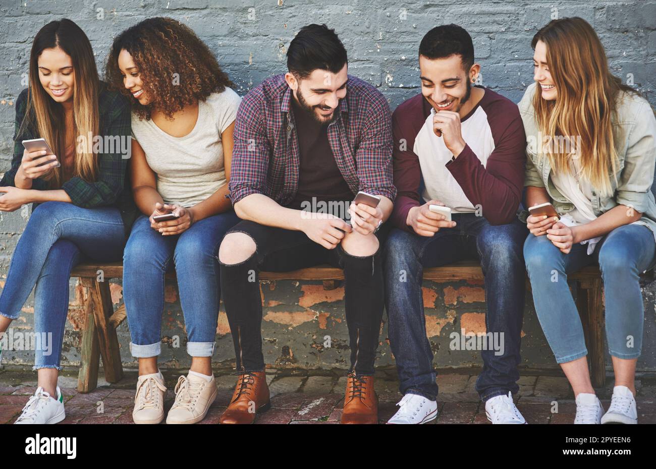 Connecting with the crew. a group of young friends using their mobile ...