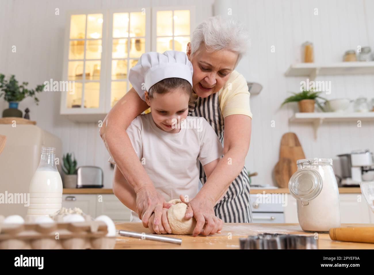 Happy family in kitchen. Grandmother and granddaughter child cook in ...