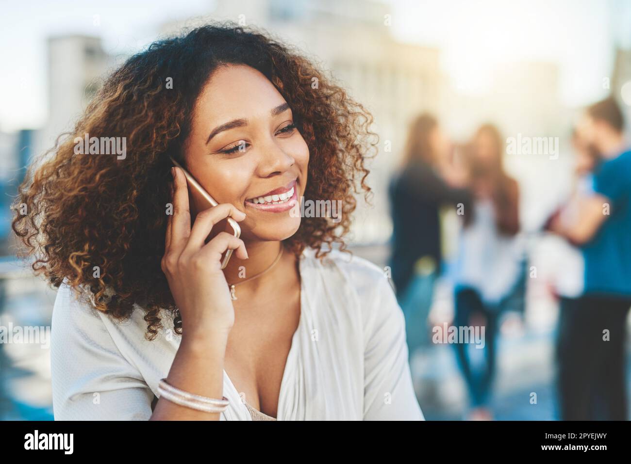 Give Me All The Details An Attractive Young Woman Making A Phone Call While Standing Outside 