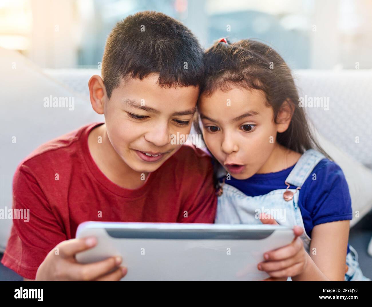 Children using technology on sofa hi-res stock photography and images ...