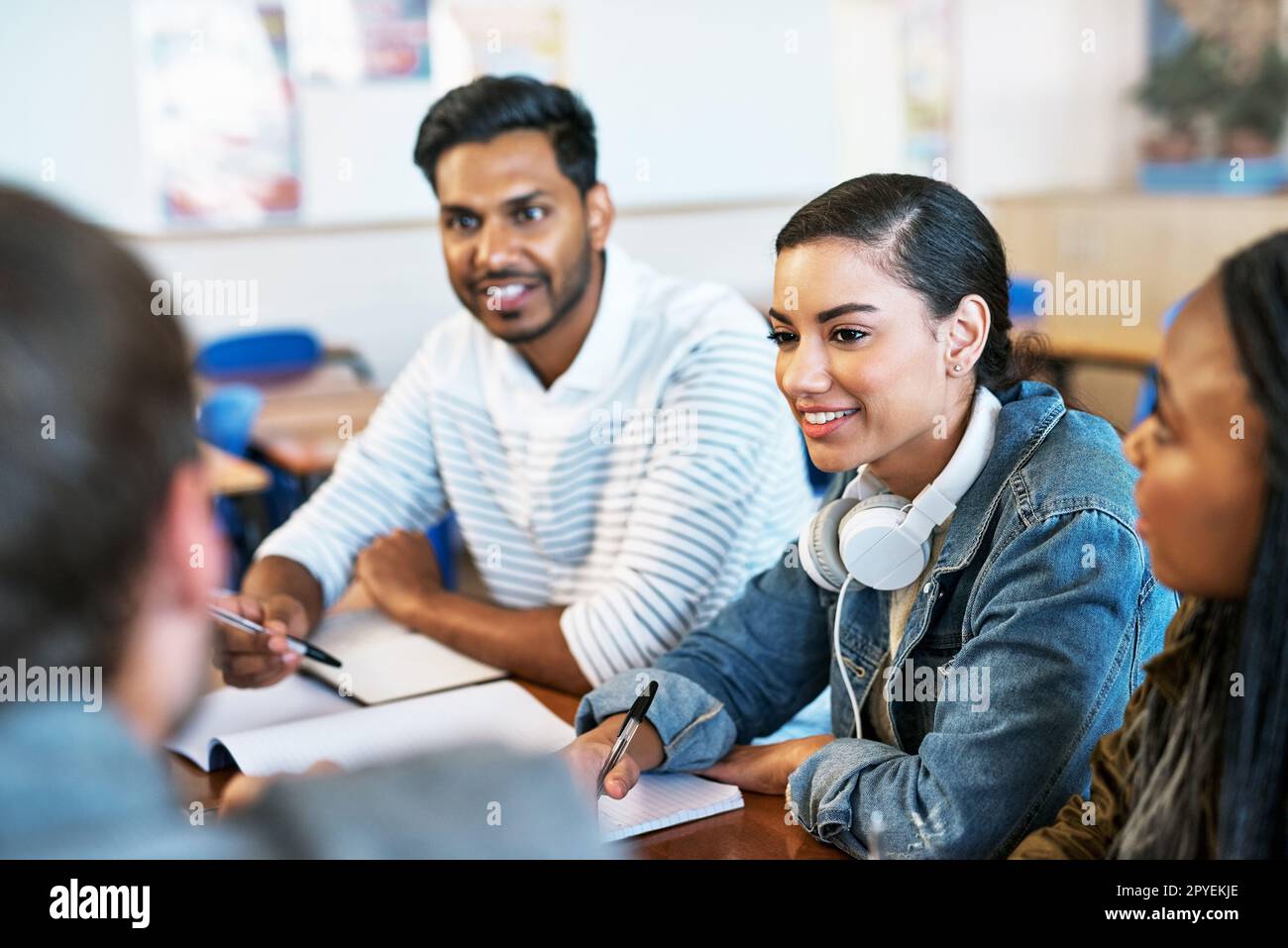 Theyre working on a group project. a group of young university students working together in ...