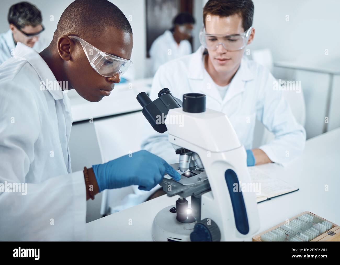 Science, laboratory and team doing research with microscope for medical ...