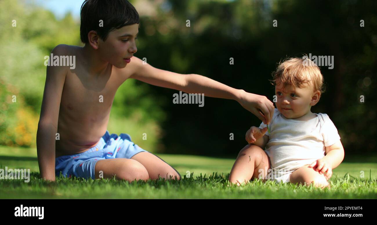 Two brothers together outside in garden Stock Photo - Alamy