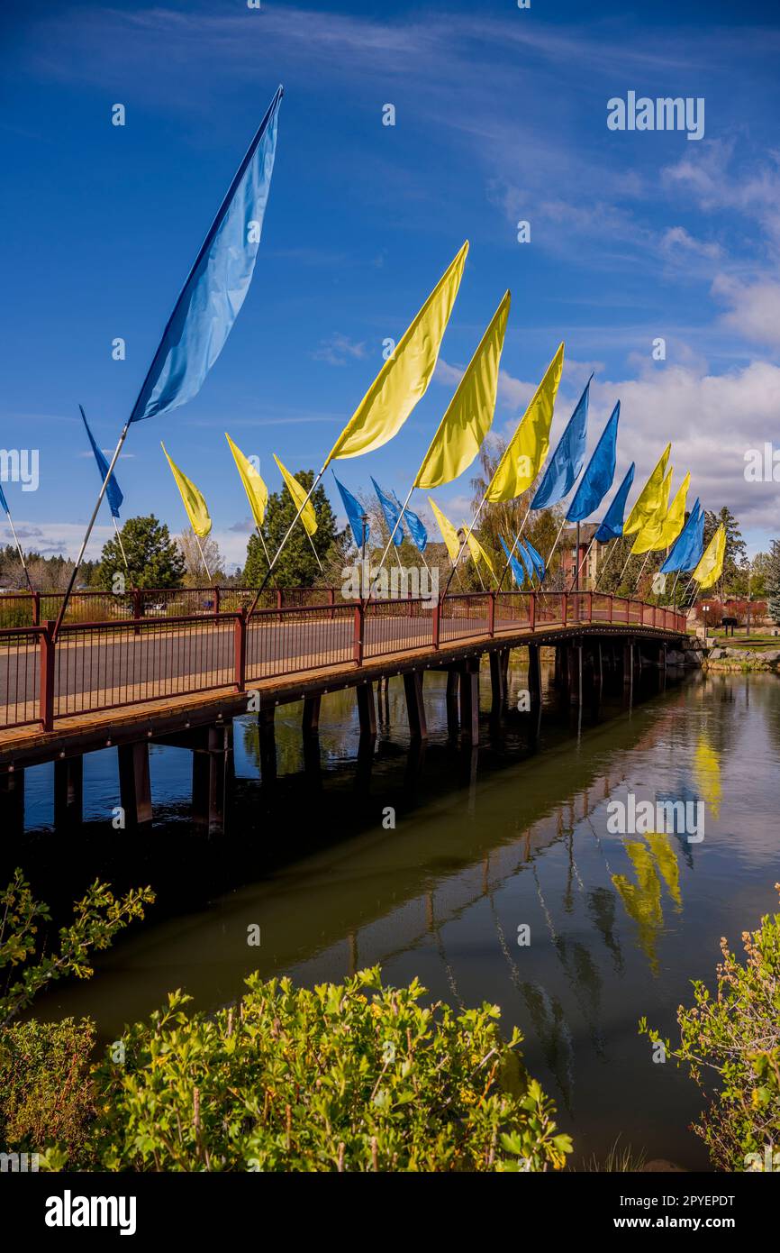 A pedestrian bridge decorated with flags over Deschutes River at the ...