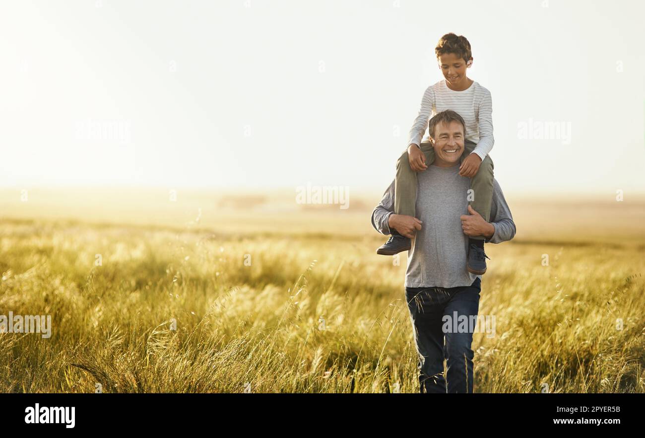 Nature creates a unique sense of wonder. a mature man carrying his son ...