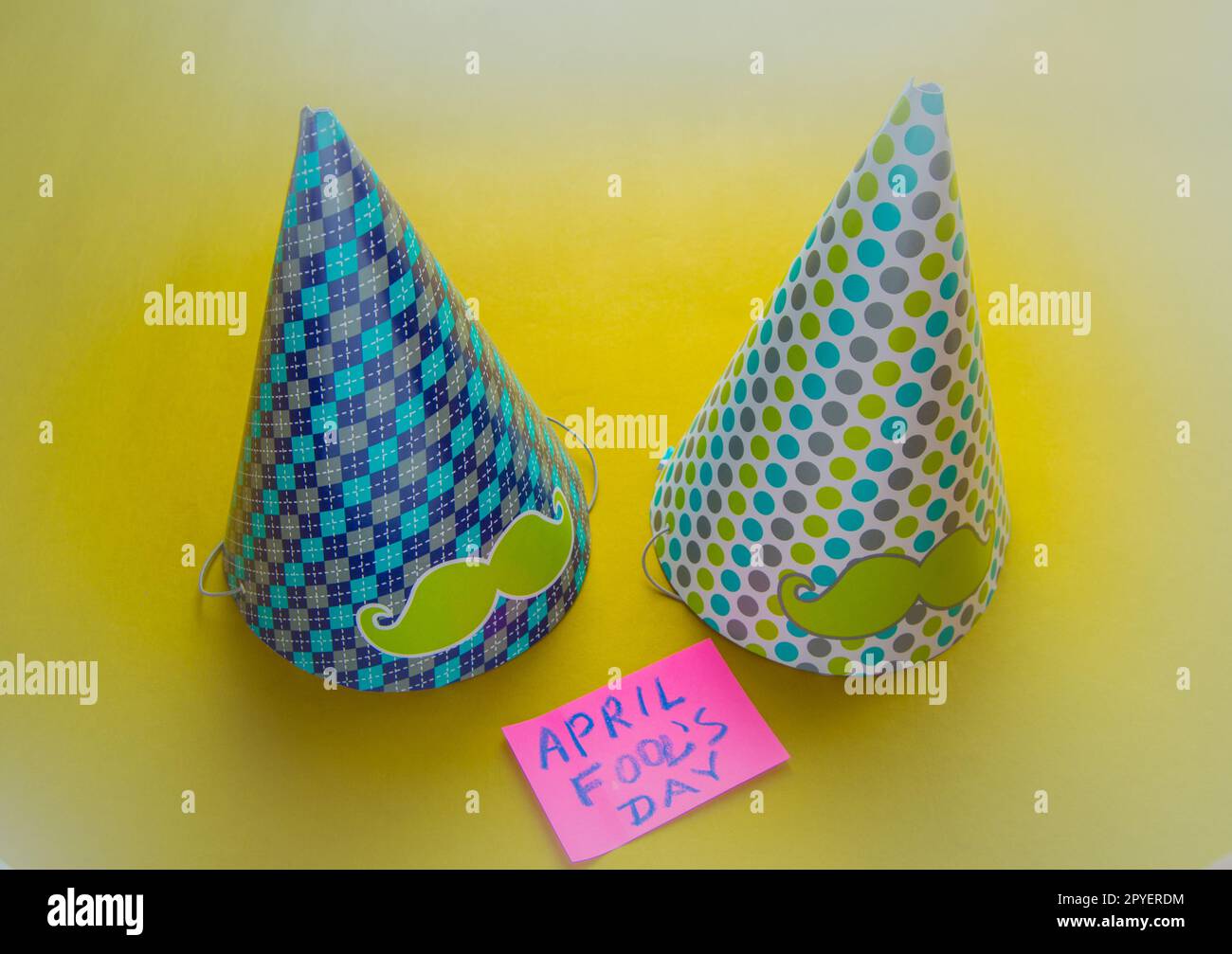 Cap, April fool's day lettering, yellow background Stock Photo - Alamy
