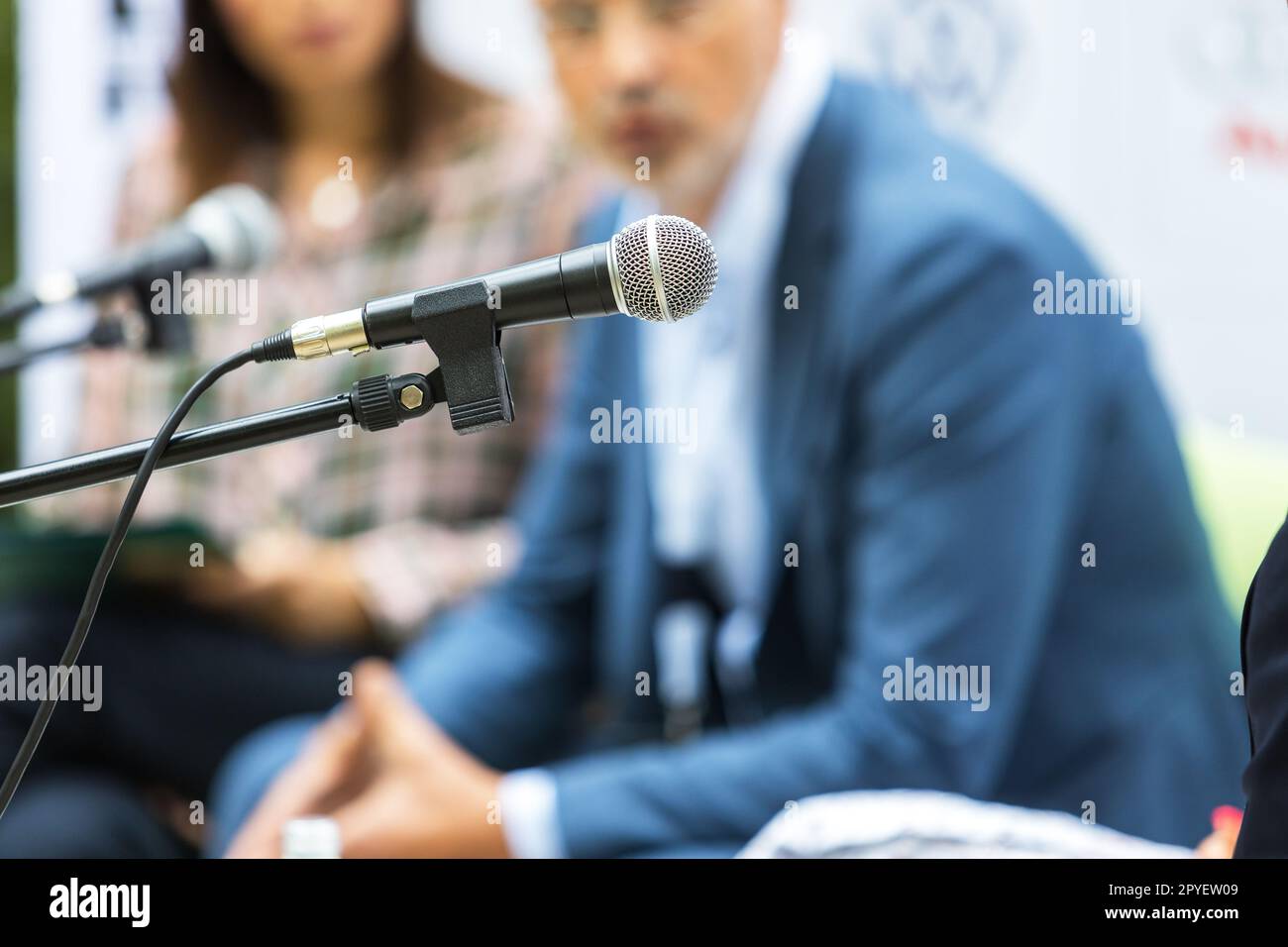 Microphone in focus at round table event or business conference. Public ...