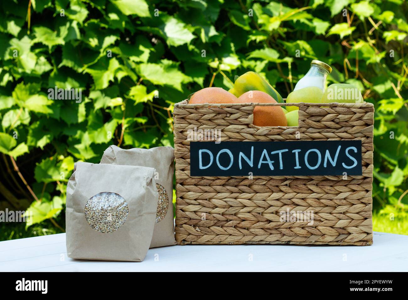 Various food in a box for donations on a table on a background of ...