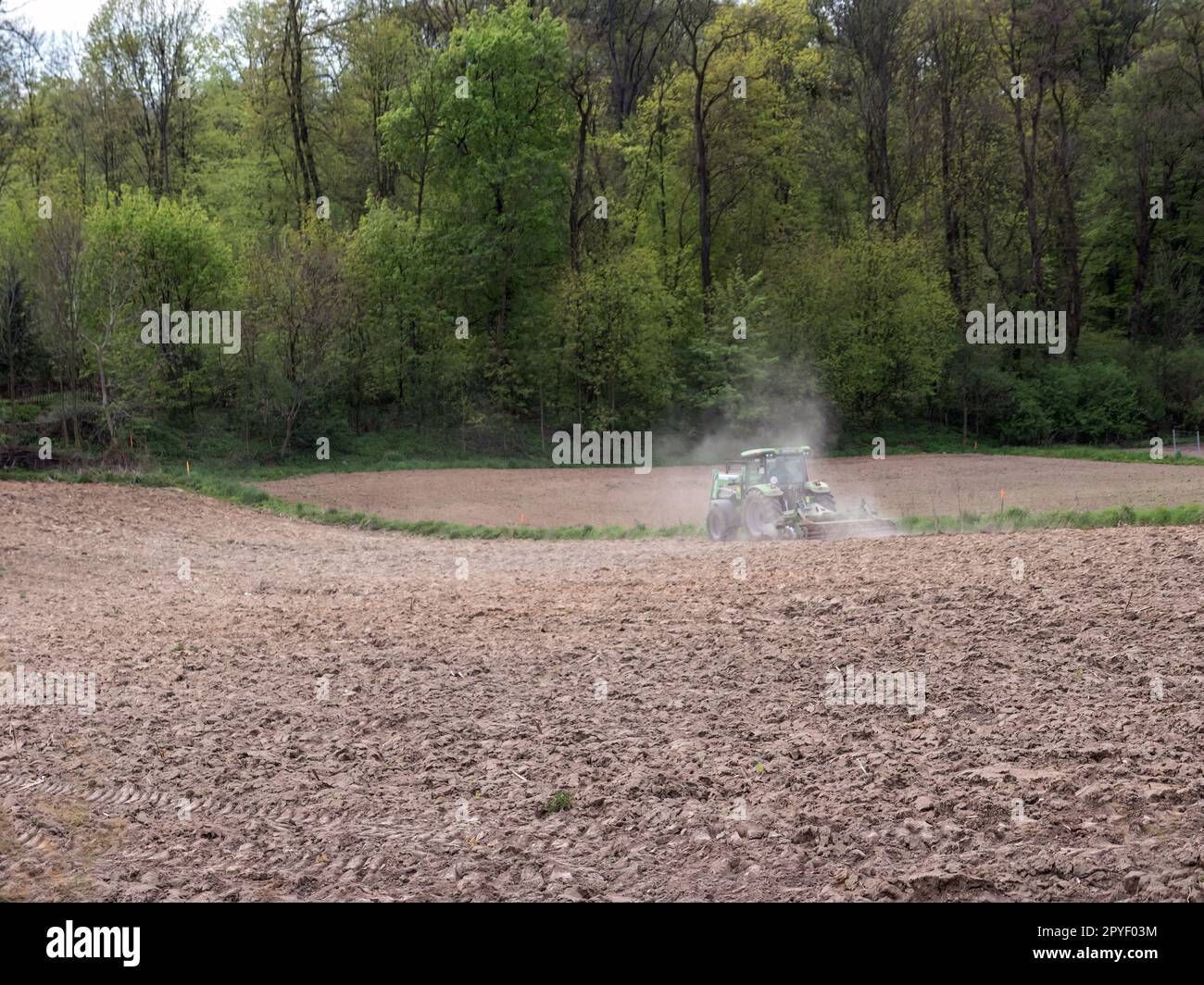 Arable field being harrowed by farm tractor Stock Photo - Alamy