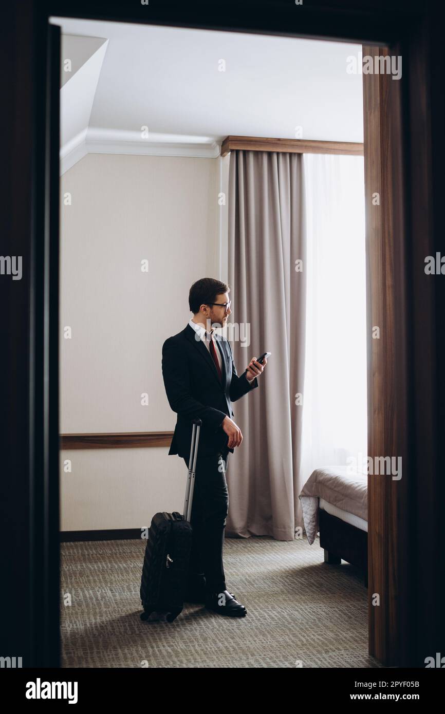 Back view of young elegant business traveler in formalwear entering ...