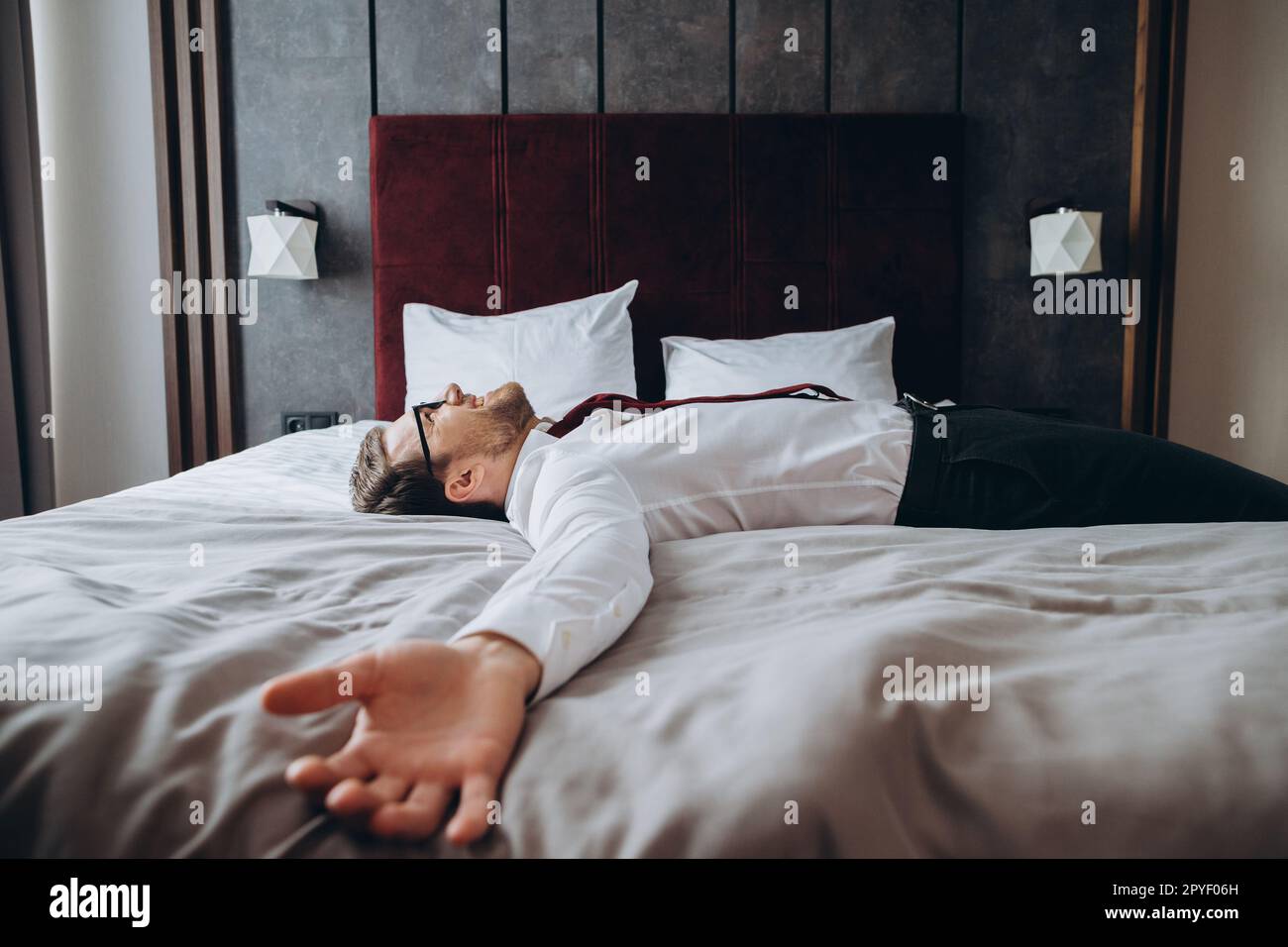 Exhausted businessman resting on bed after long air flight, jet lag ...