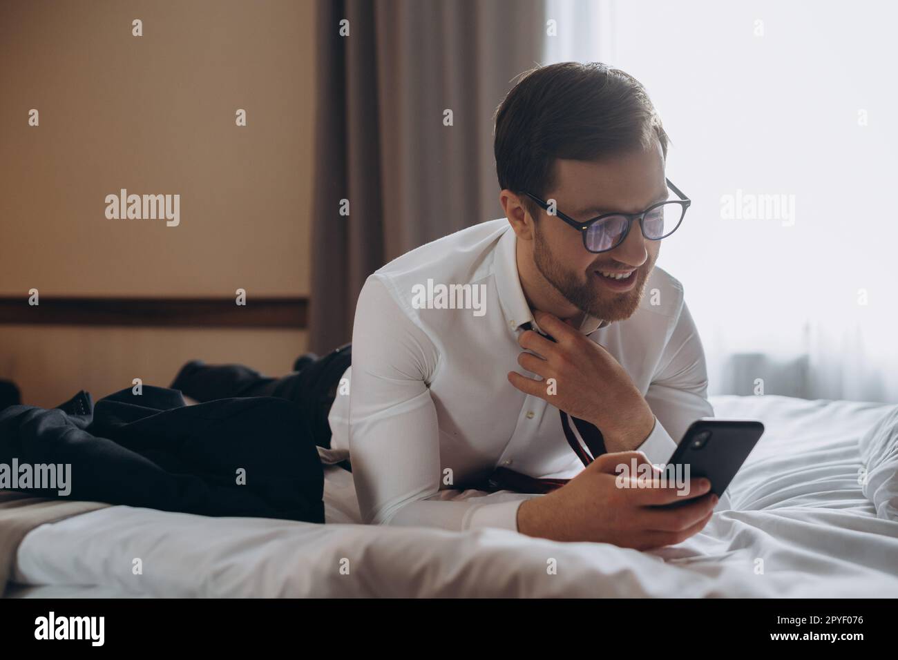 Young businessman working from a hotel room with his mobile phone Stock ...