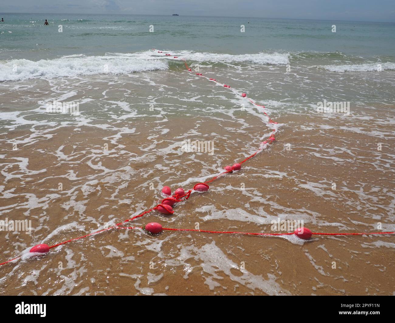 Buoys on a rope in sea water. The lifebuoys are pink restraints to ...