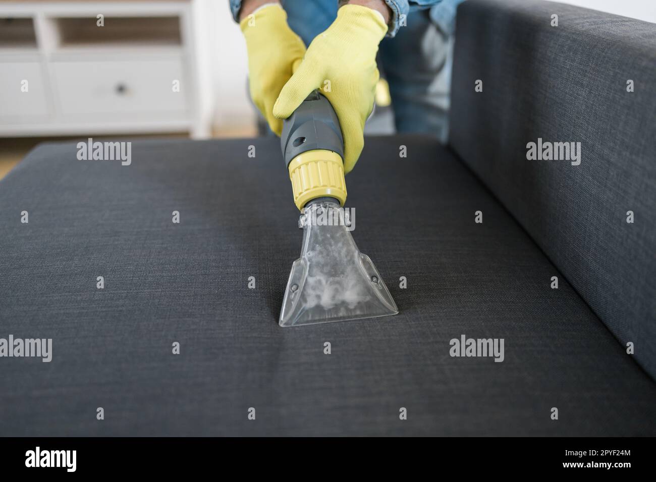 Man dry cleaner's employee hand in protective rubber glove cleaning ...