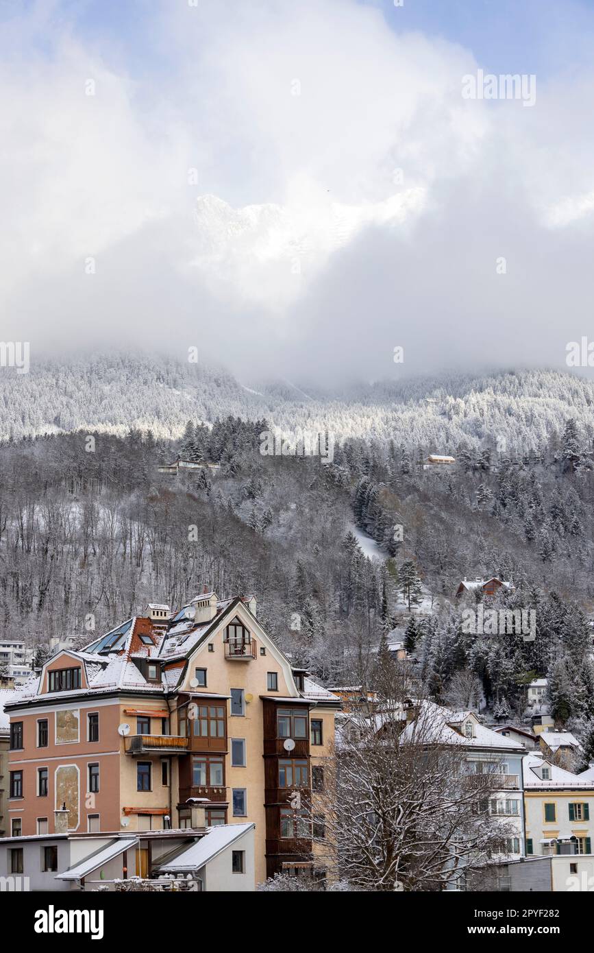 View of the snow peaks of the Alps mountains above the city, clouds ...