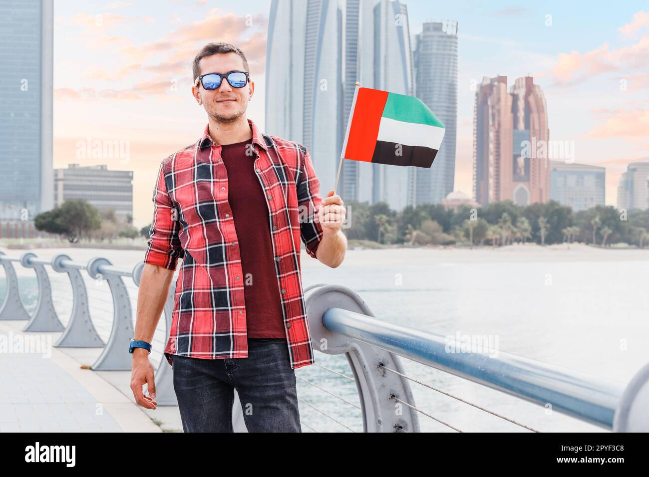 A proud UAE citizen poses with the national flag, embodying the ...