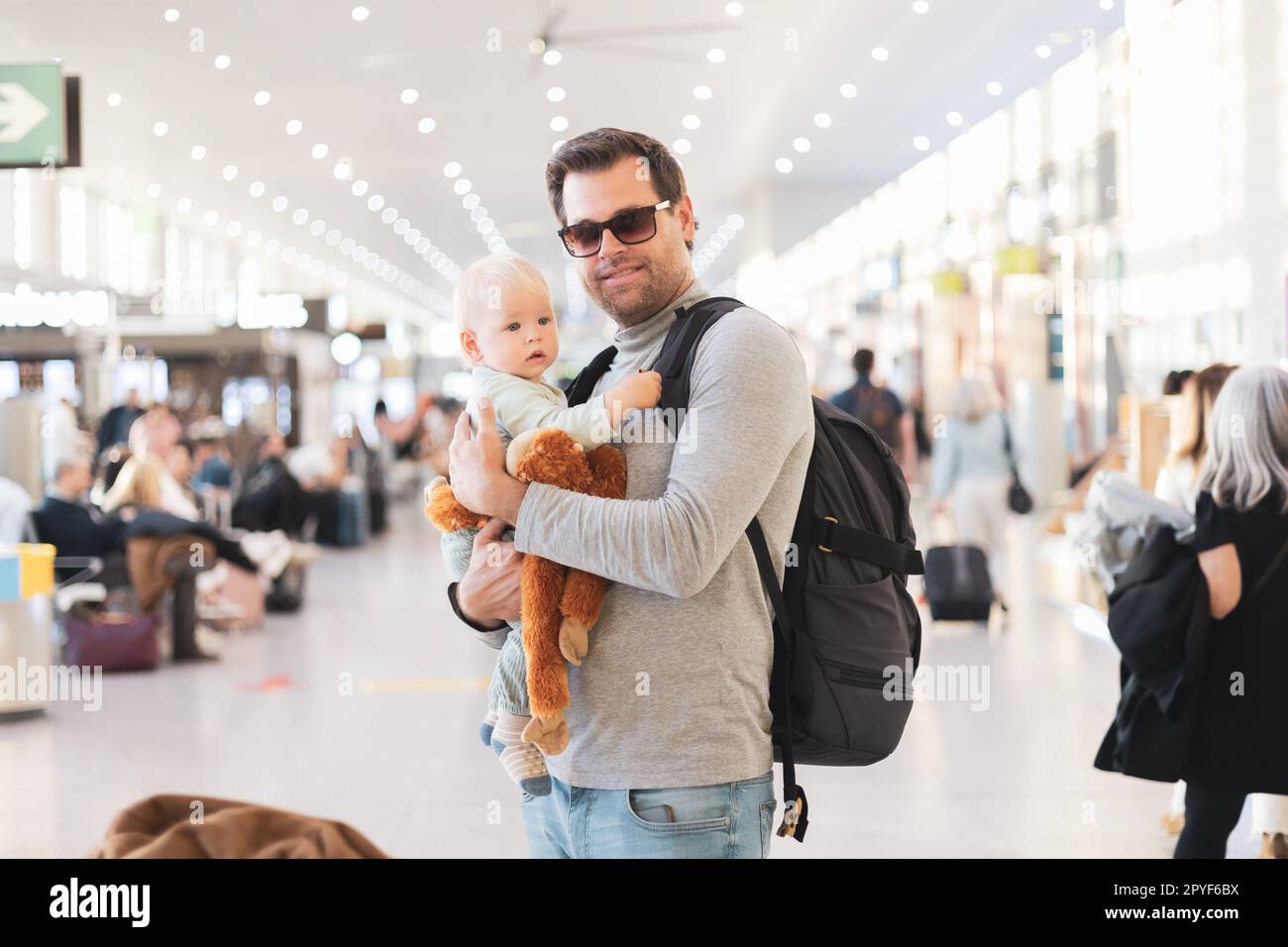 Father traveling with child, holding his infant baby boy at airport ...