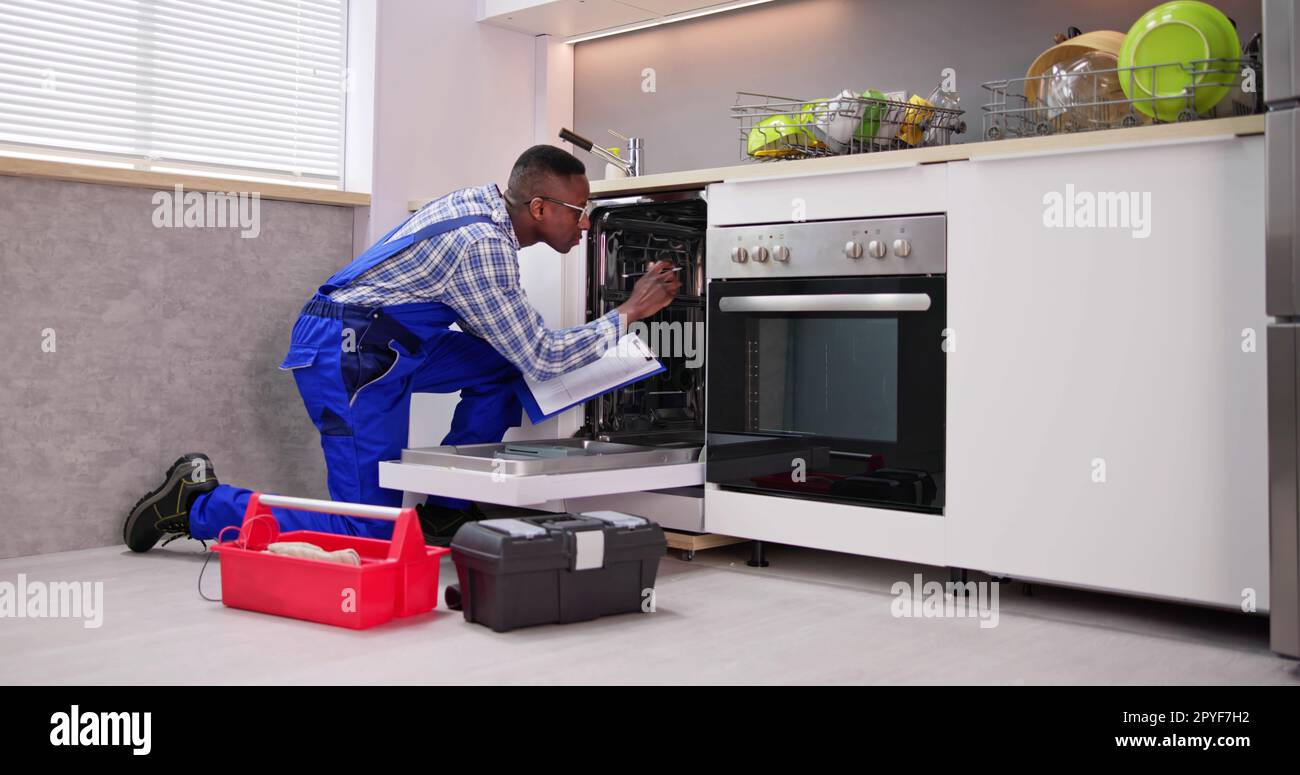 African American Repairman Fixing Dishwasher Appliance Stock Photo - Alamy