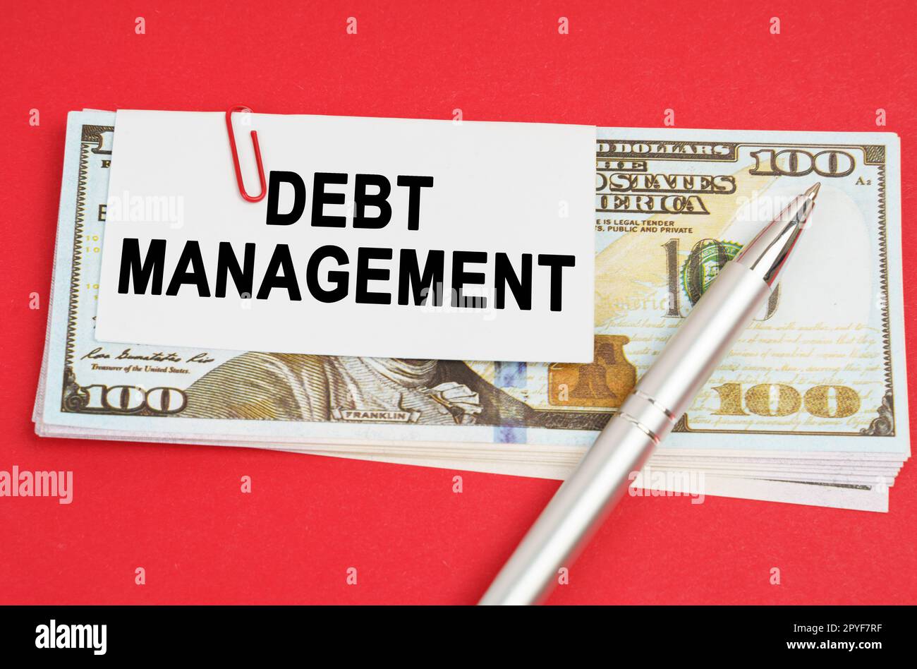 Business concept. On a red surface are dollars on which a pen and paper ...