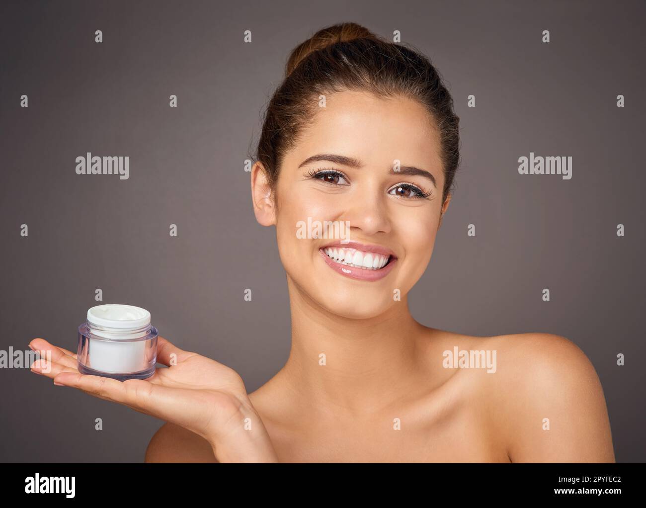 Its my beauty secret. Portrait of a beautiful young model holding up a ...