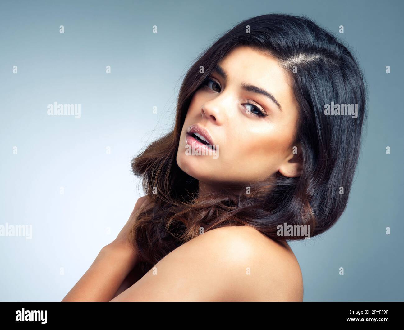 Shes an absolute stunner. Studio portrait of a beautiful young woman posing against a gray ...