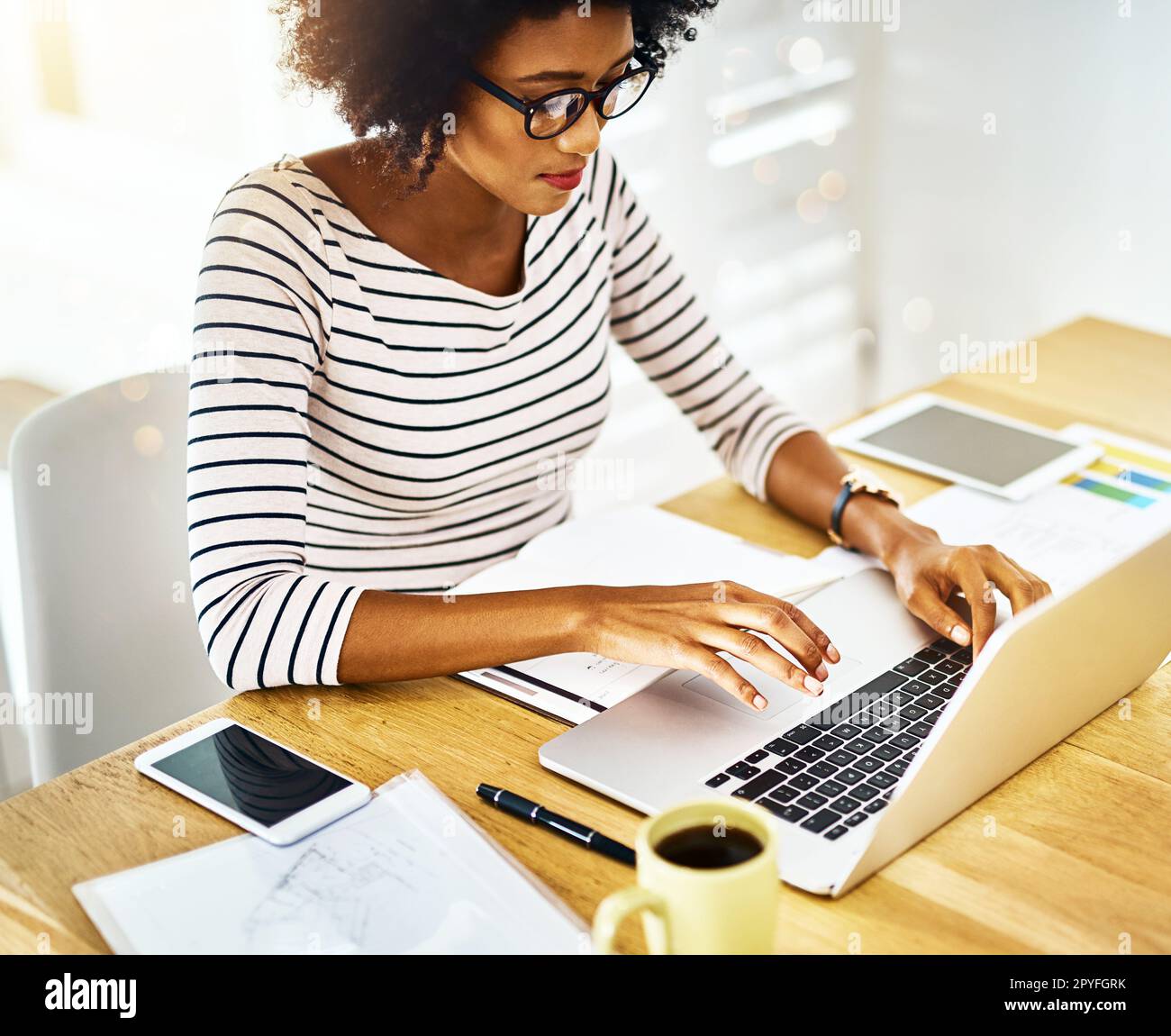 Lets see how the statistics are doing. a focused young woman working on ...