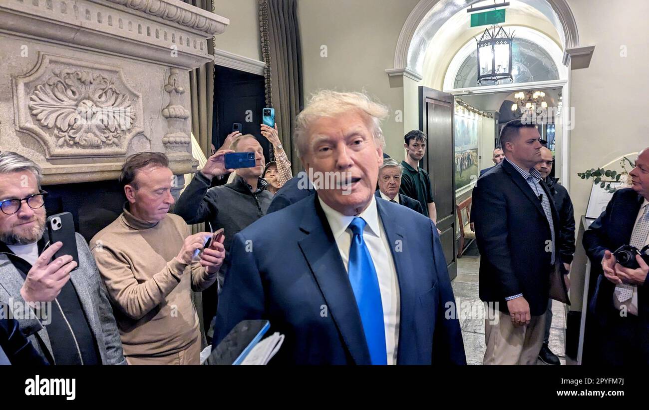 Former US president Donald Trump speaks to reporters as he arrives at ...