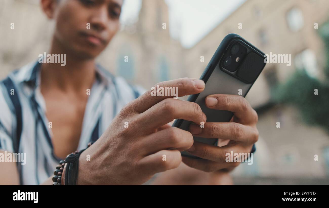 Young man tourist on steps uses mobile phone while sitting on landmarks ...