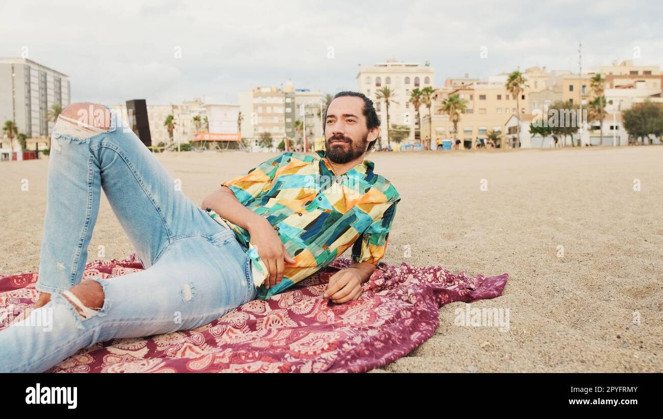 Young man lies and relaxing on the beach Stock Photo - Alamy