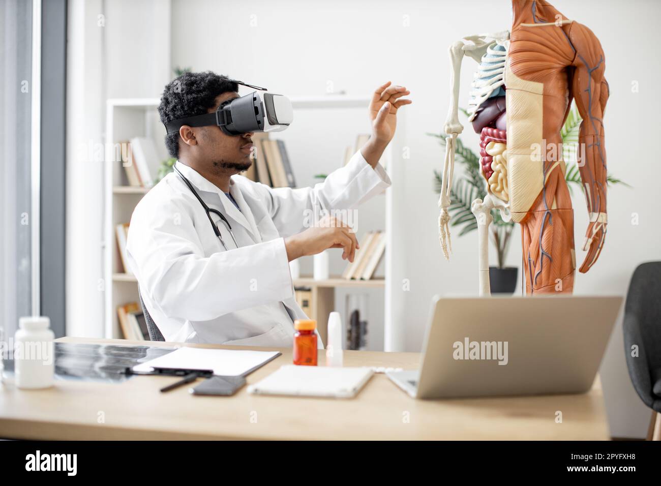 Side view of multiethnic male in white coat using virtual reality ...