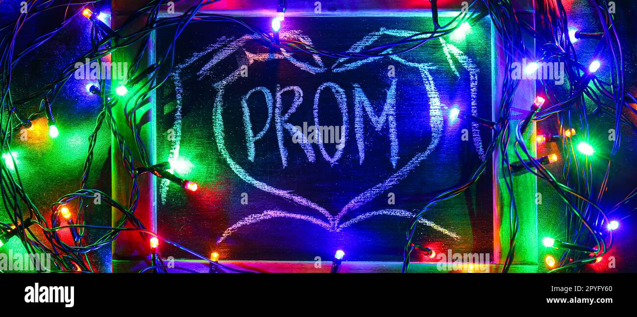 Chalkboard with word PROM and glowing colorful lights on dark ...