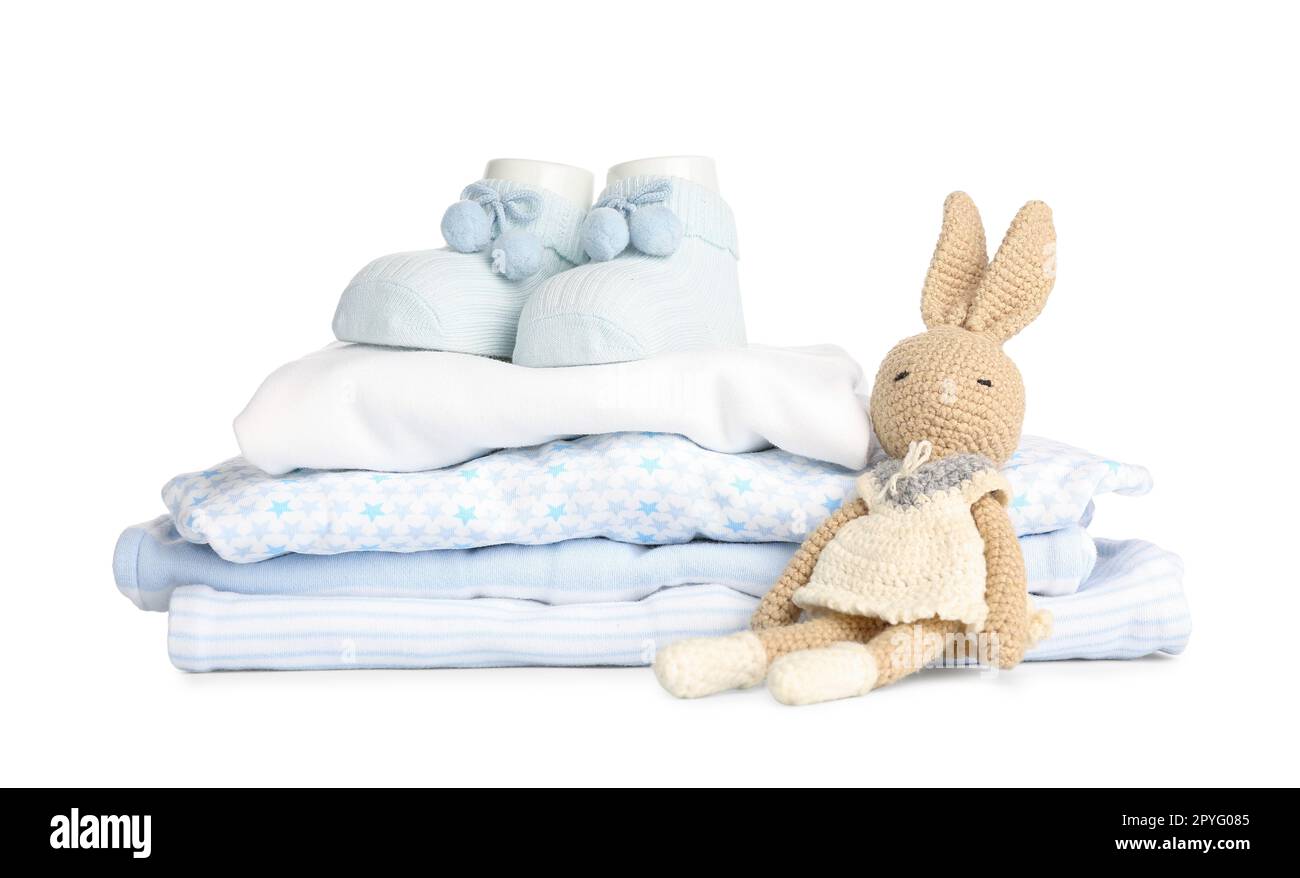 Stack of baby clothes and knitted toy on white background Stock Photo ...